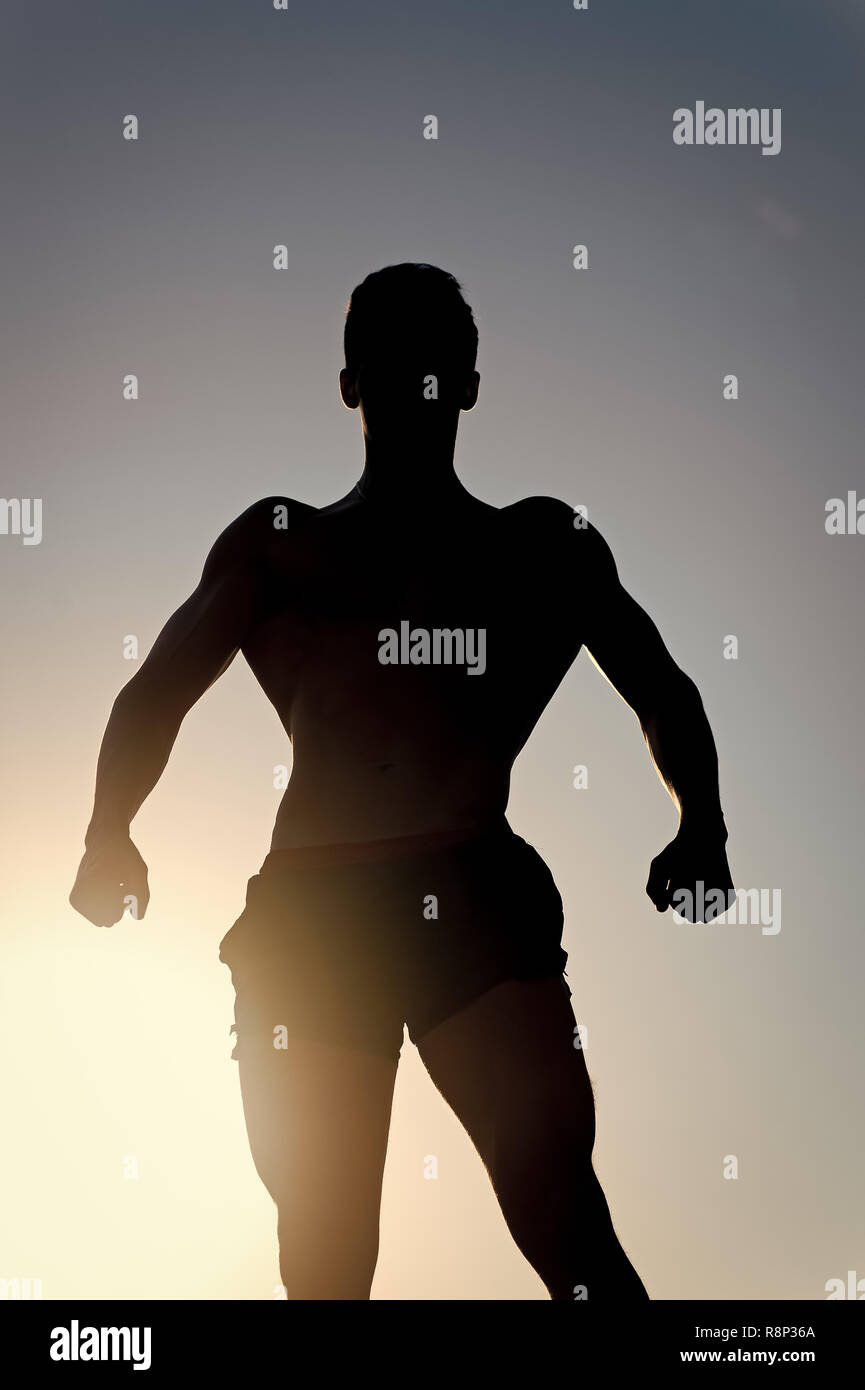 Sportsman relaxing muscles, biceps, triceps outdoors. Bodybuilder ...