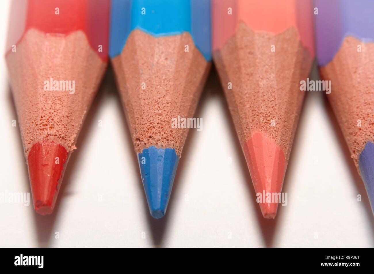 Macro of red blue pink purple color pencils, all lined up on white ...