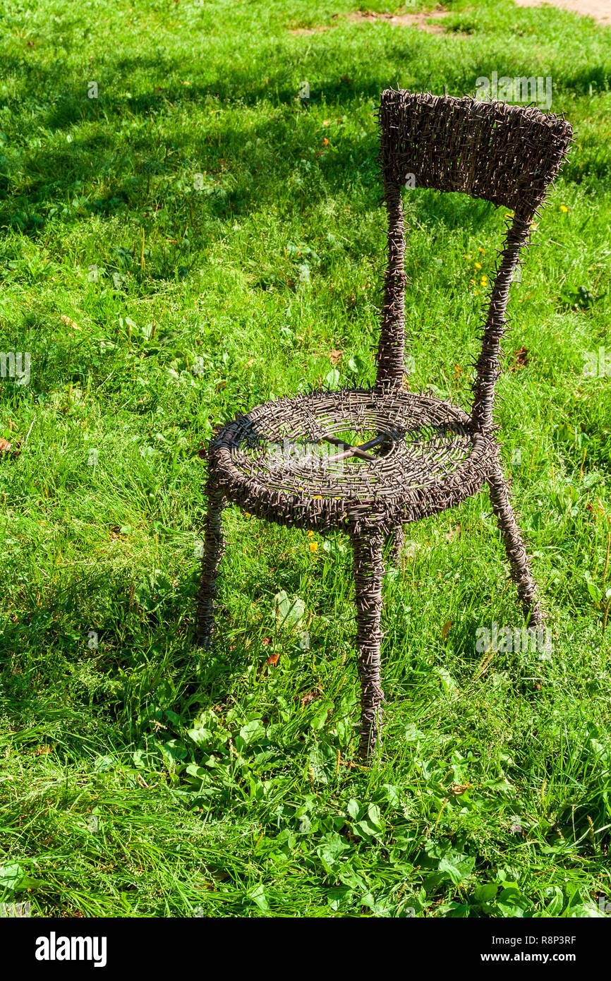 barber wire chair in the green meadow with foliage Stock Photo - Alamy