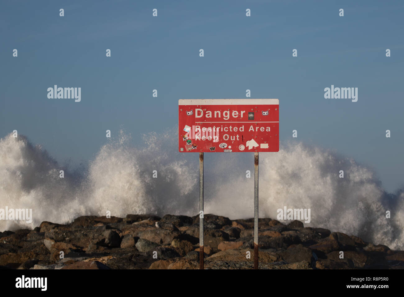 Danger restricted area keep out warning sign with crashing waves in the ...