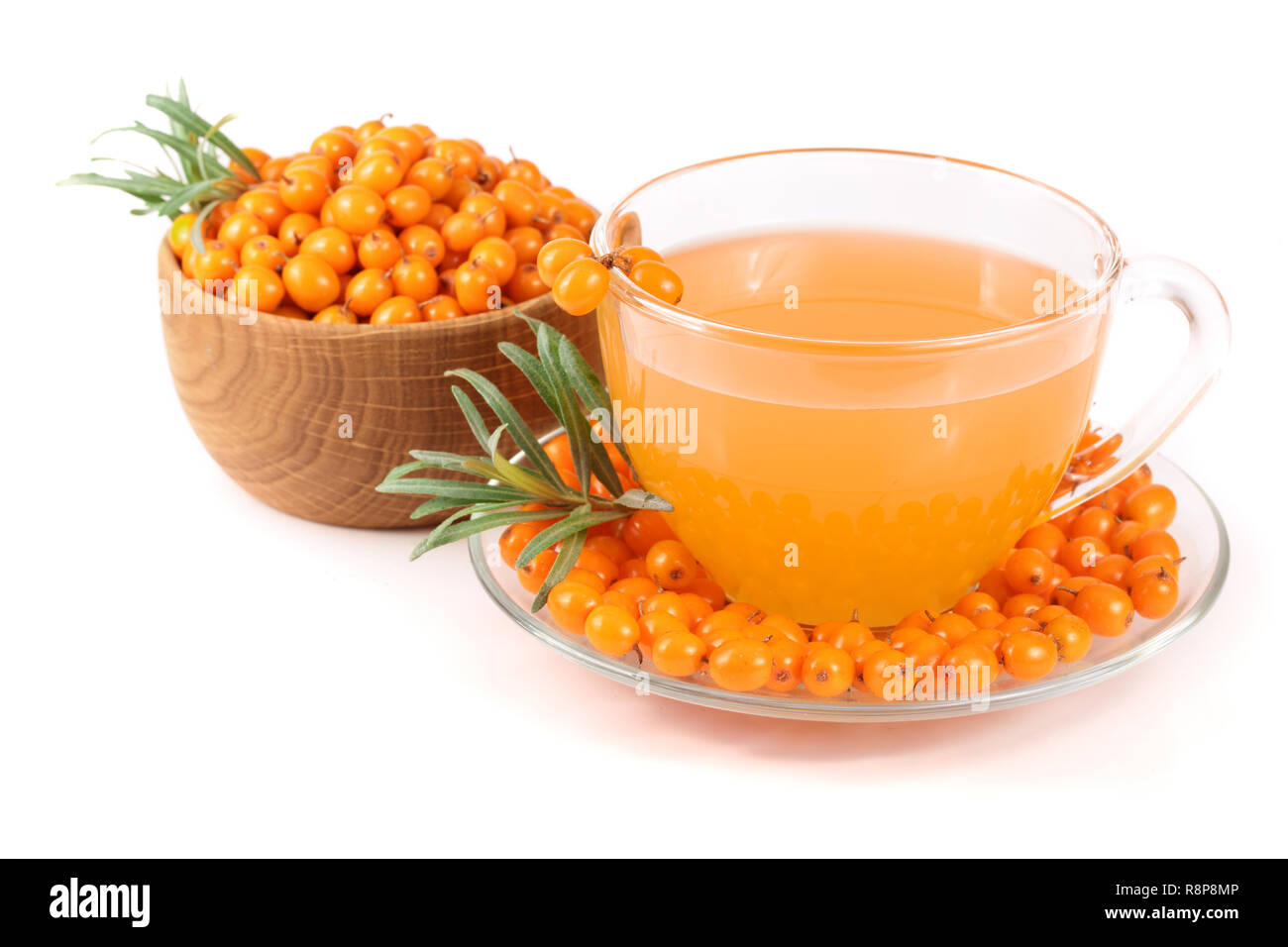 Sea buckthorn tea in a glass and wooden bowl with berries isolated on ...