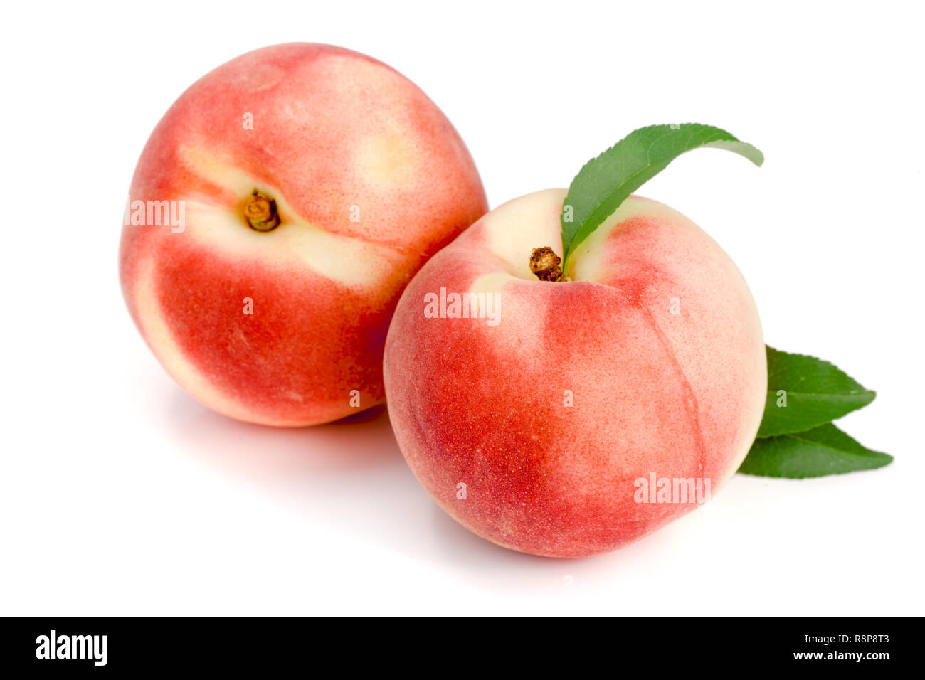Two peaches with green leaf isolated on white background Stock Photo ...