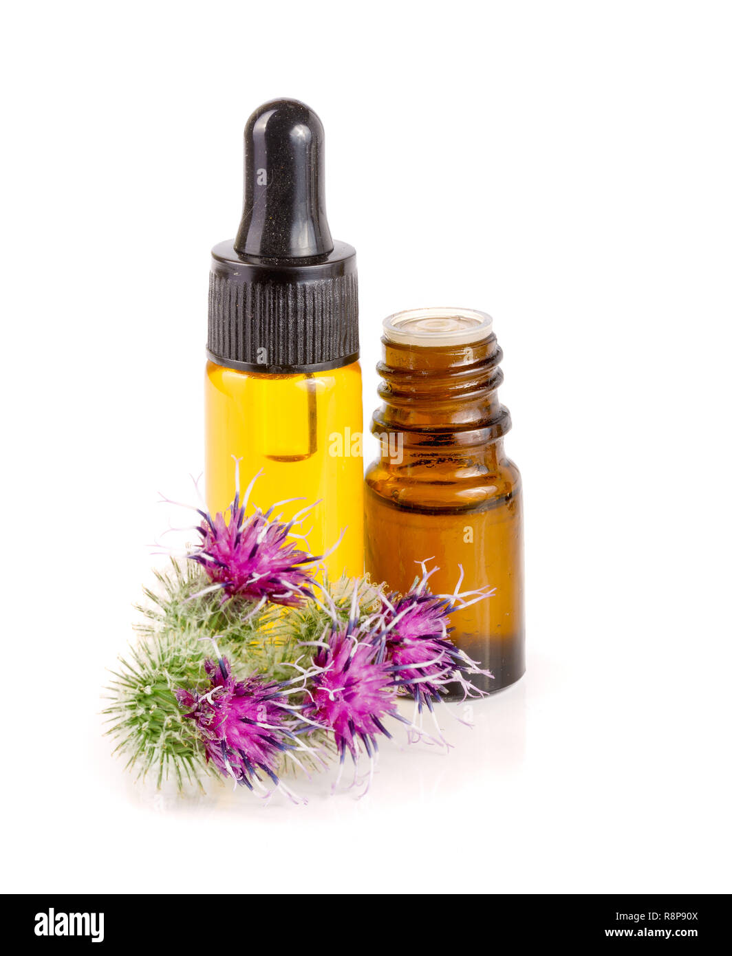 burdock oil in glass bottle and burdock flowers isolated on white ...