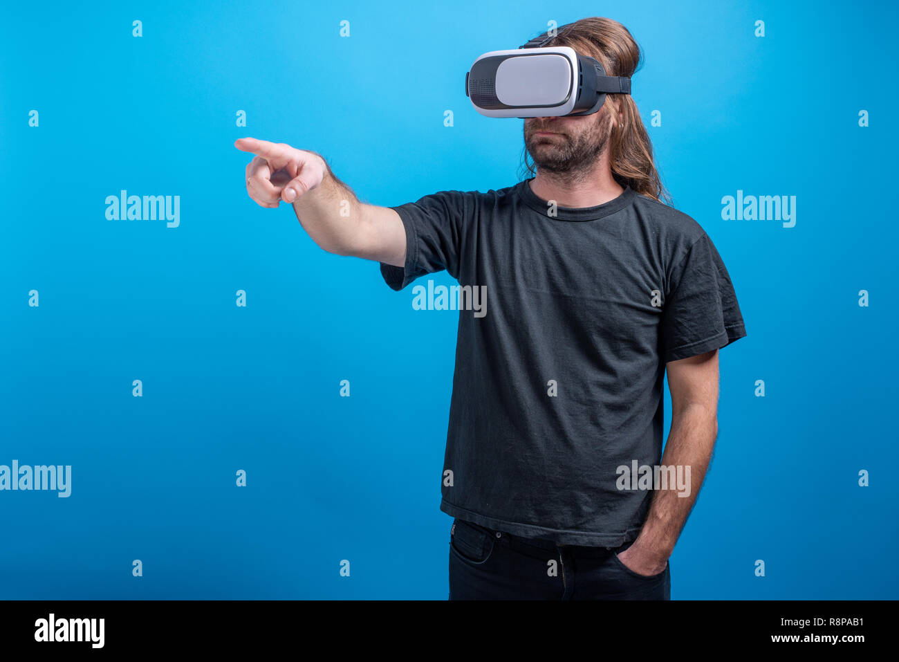 Portrait of Male wearing VR device pointing direction whith hand in ...