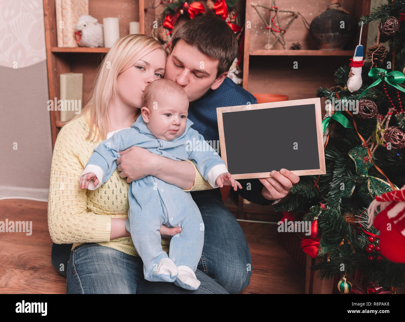 young happy parents showing blank Christmas card Stock Photo - Alamy