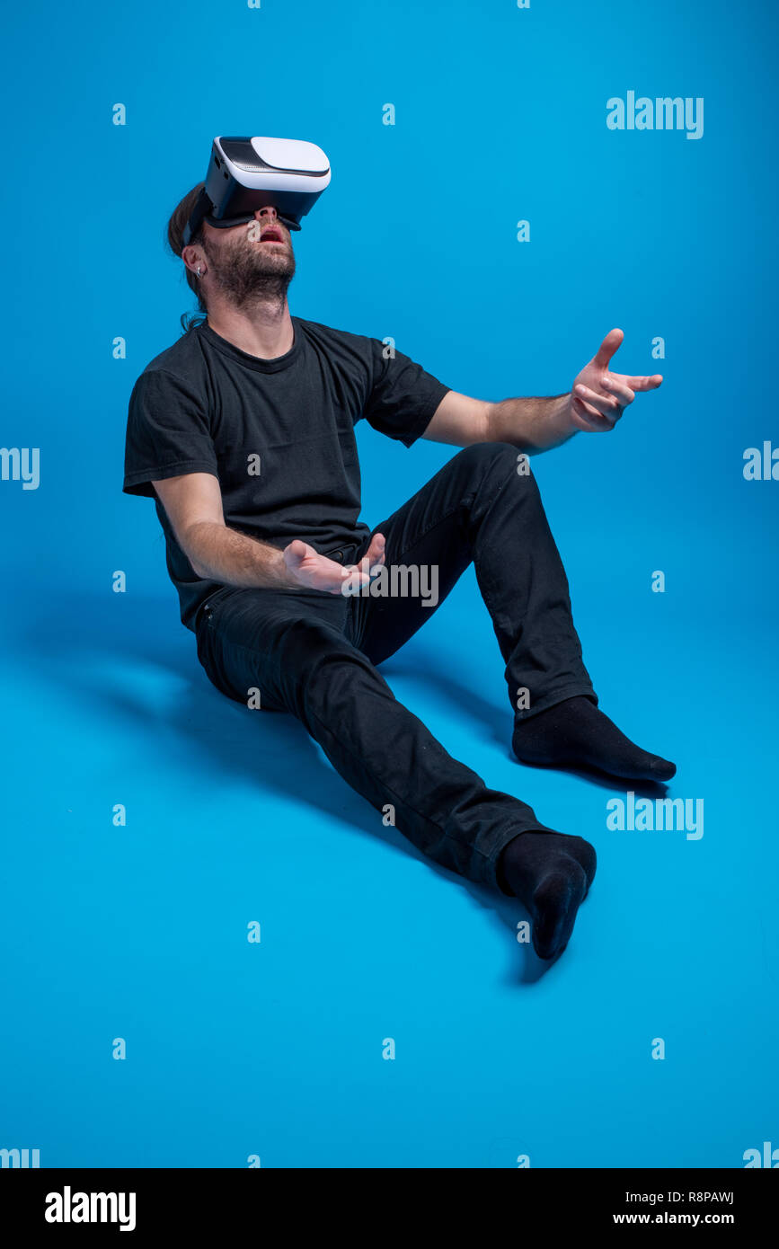 Man standing down and wearing the VR gadget showing amazed expression ...