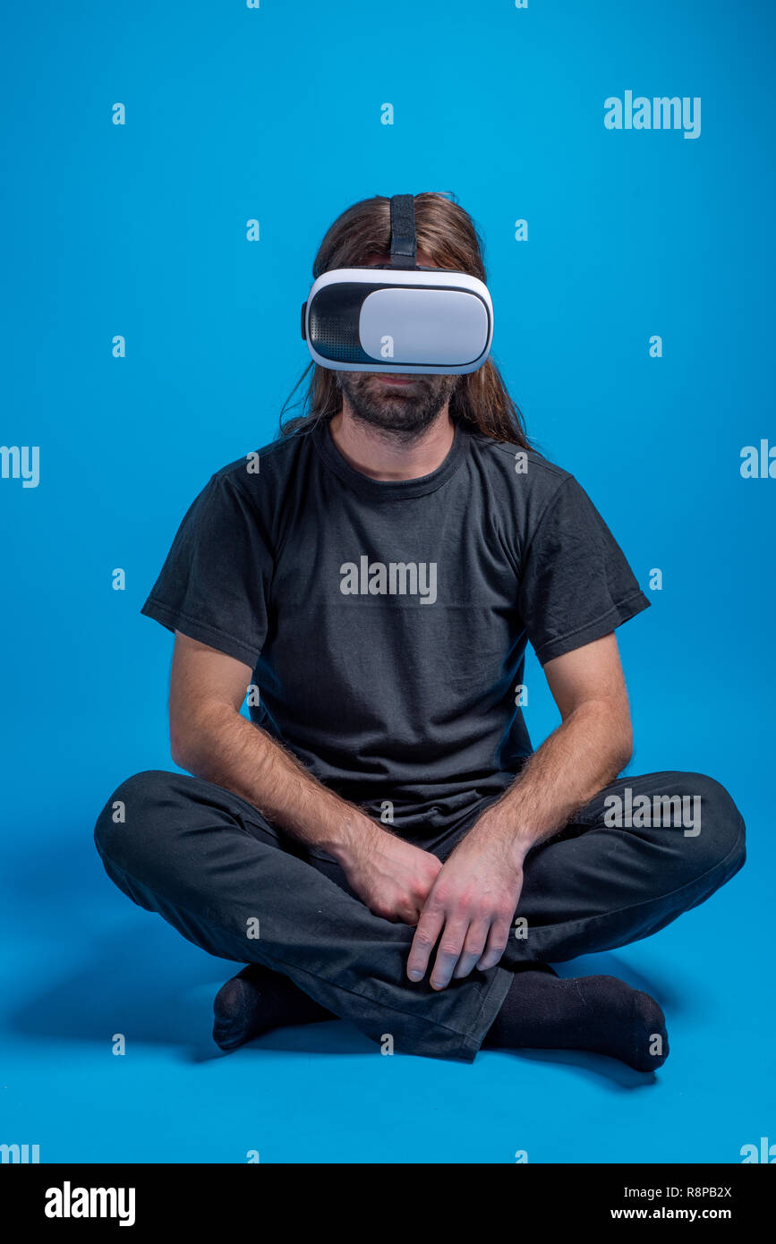Male portrait wearing VR gear laying on the ground. Technology device ...
