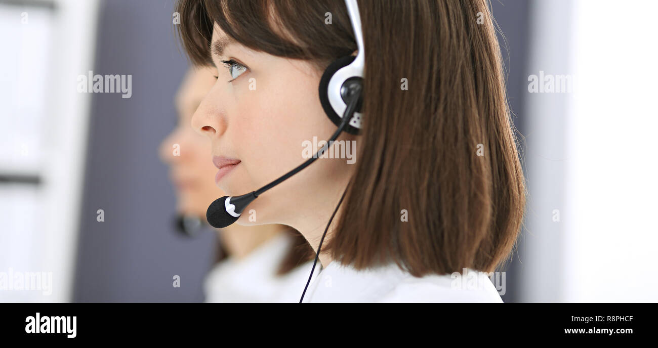 Call center. Group of operators at work. Focus on young brunette woman. Business concept Stock ...