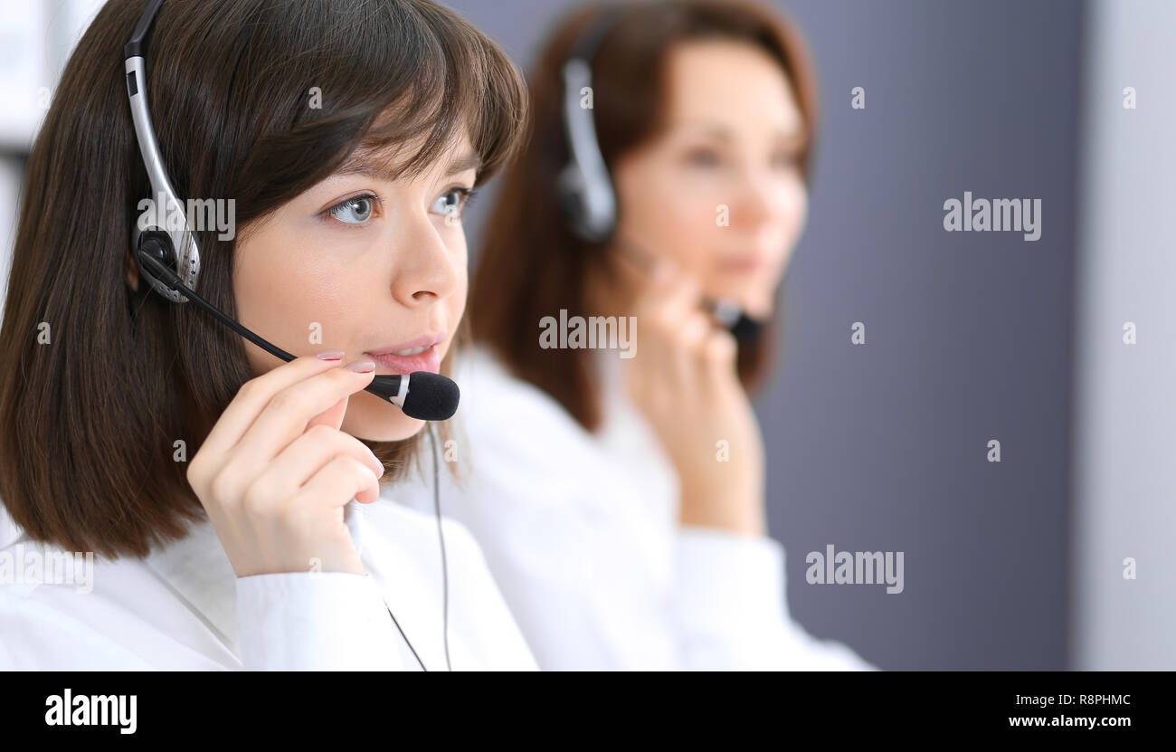 Call center. Group of operators at work. Focus on young brunette woman ...