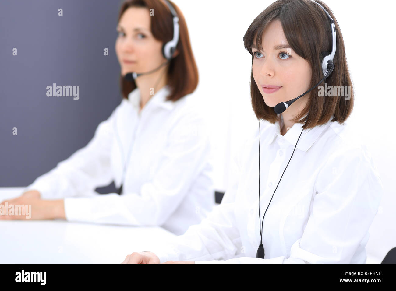 Call center. Group of operators at work. Focus on young brunette woman. Business concept Stock ...