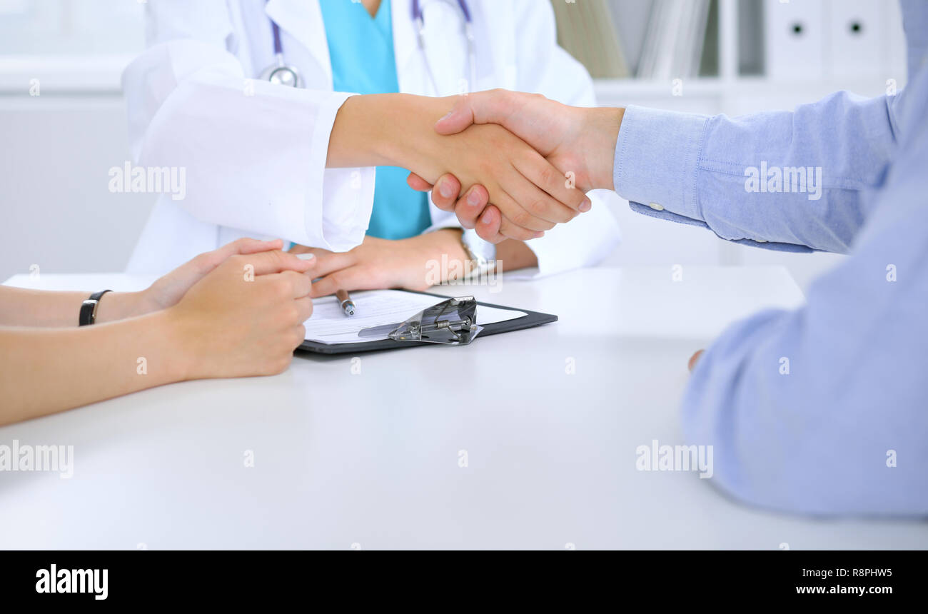 Doctor and patient shaking hands. Family couple at medical exam, just ...