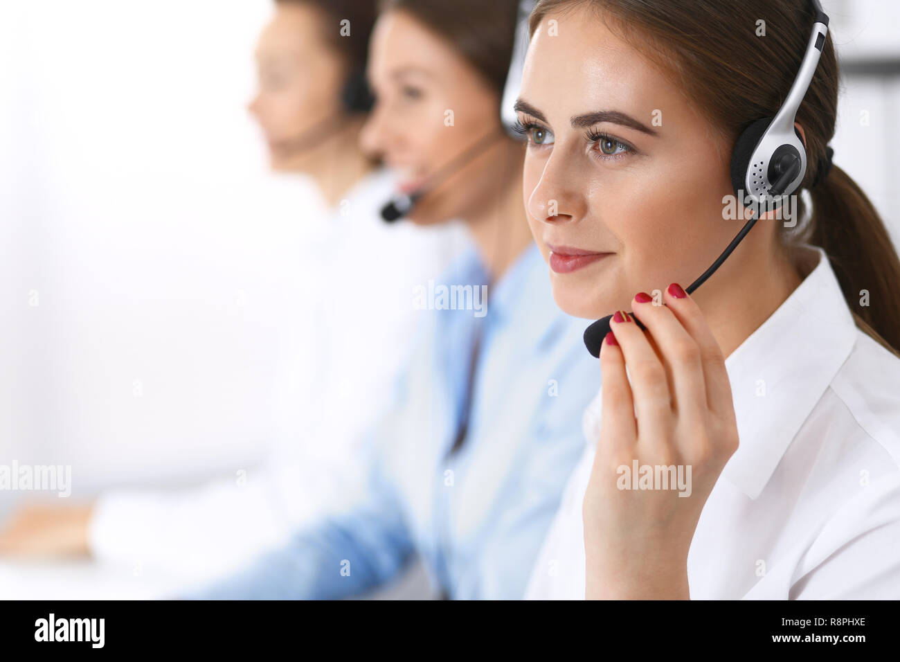 Call center. Group of operators at work. Focus at beautiful business woman in headset Stock ...