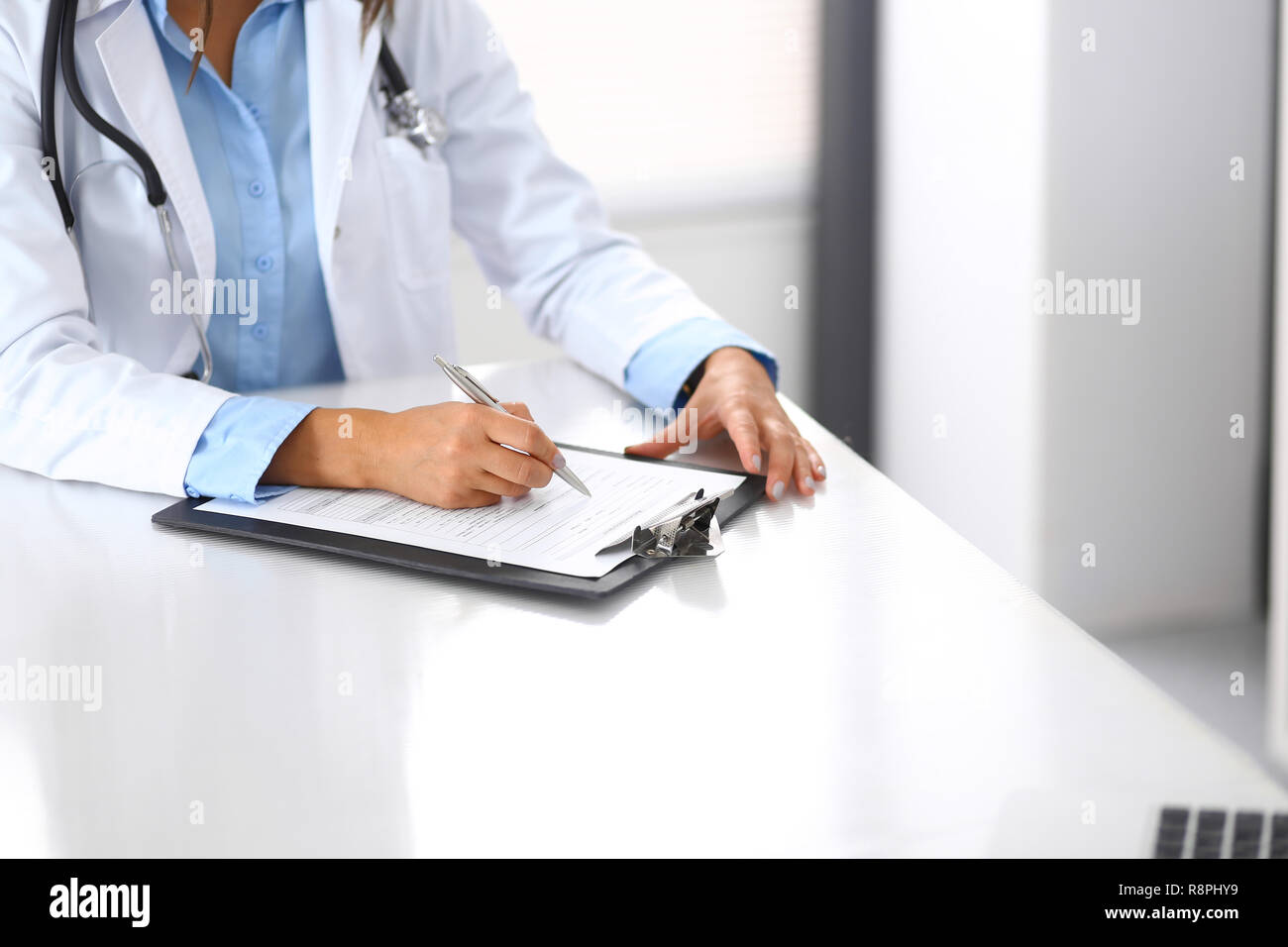Unknown doctor woman sitting writing hi-res stock photography and ...