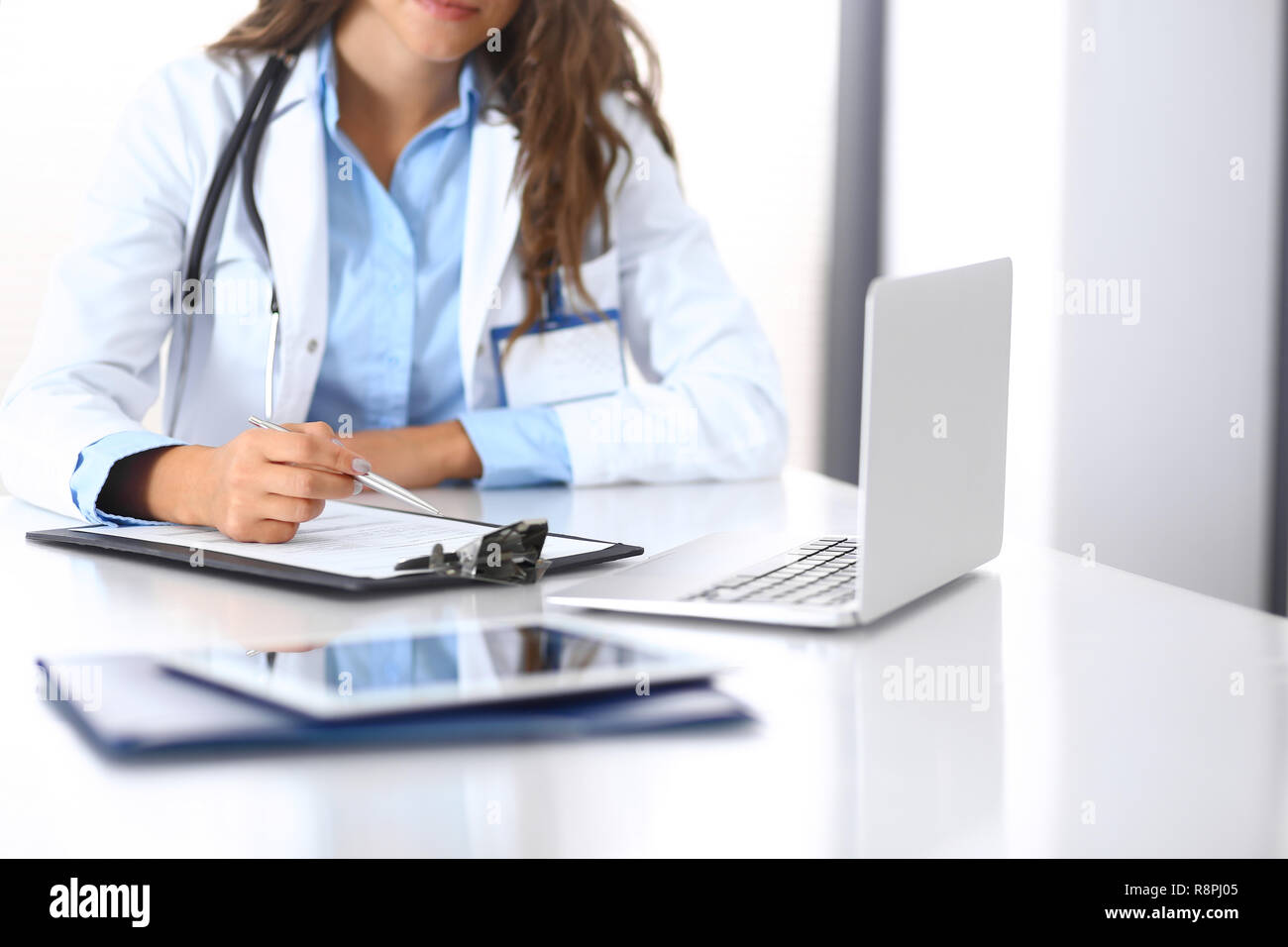 Unknown doctor woman sitting writing hi-res stock photography and ...