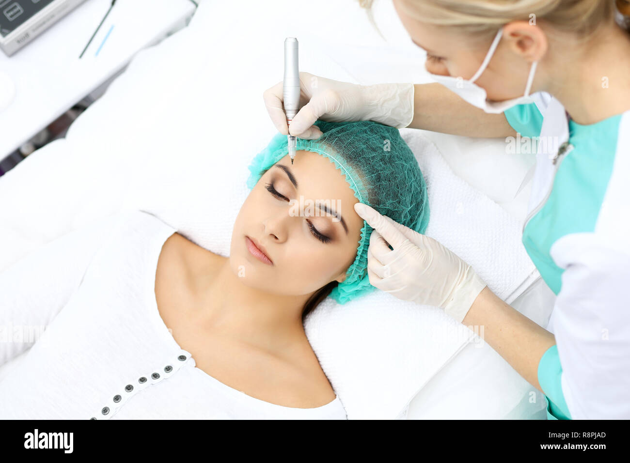 Professional beautician doing eyebrow tattoo at woman face. Permanent ...