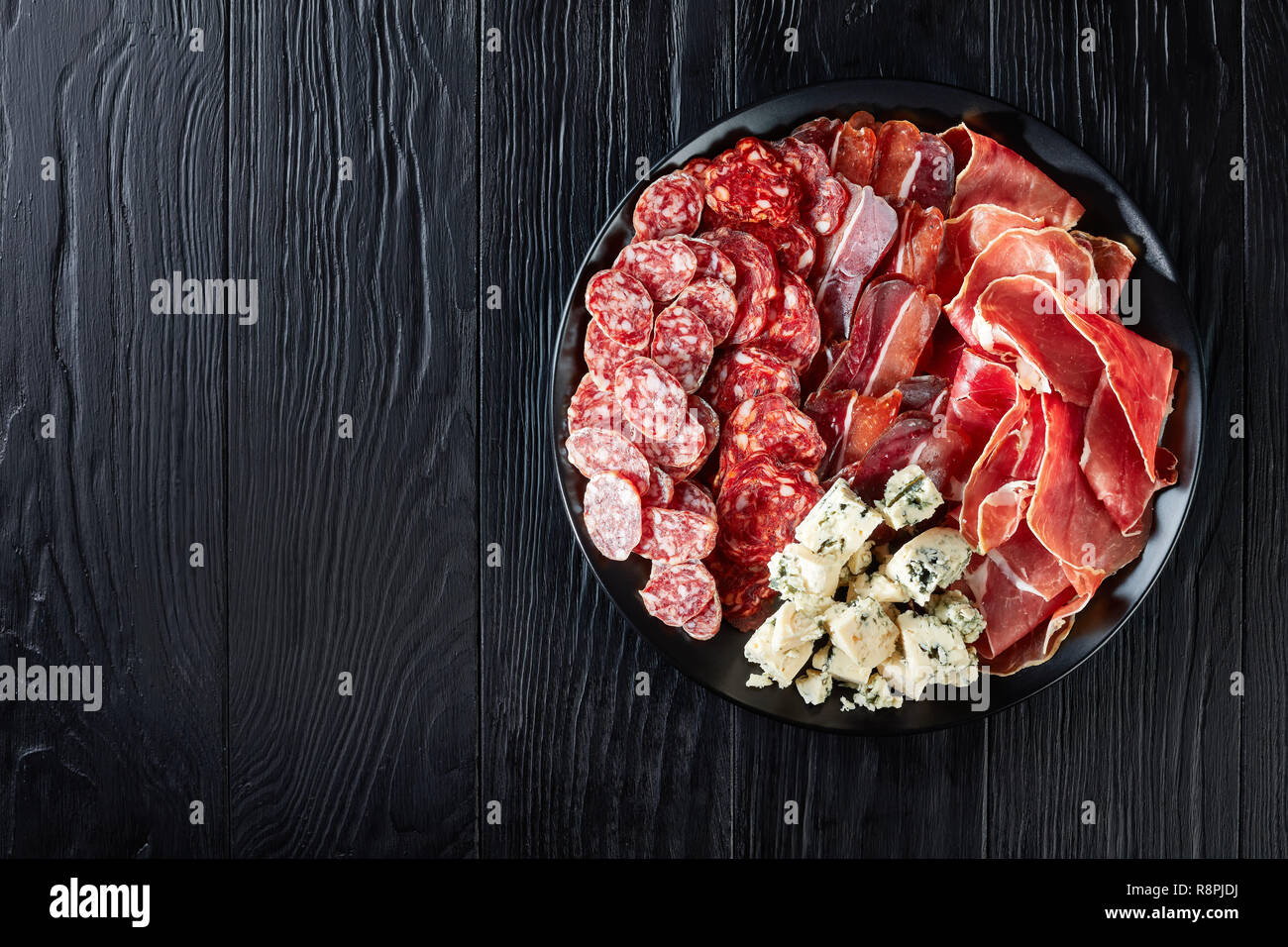 overhead view of antipasti - cheese, sausages and dry cured meat ...