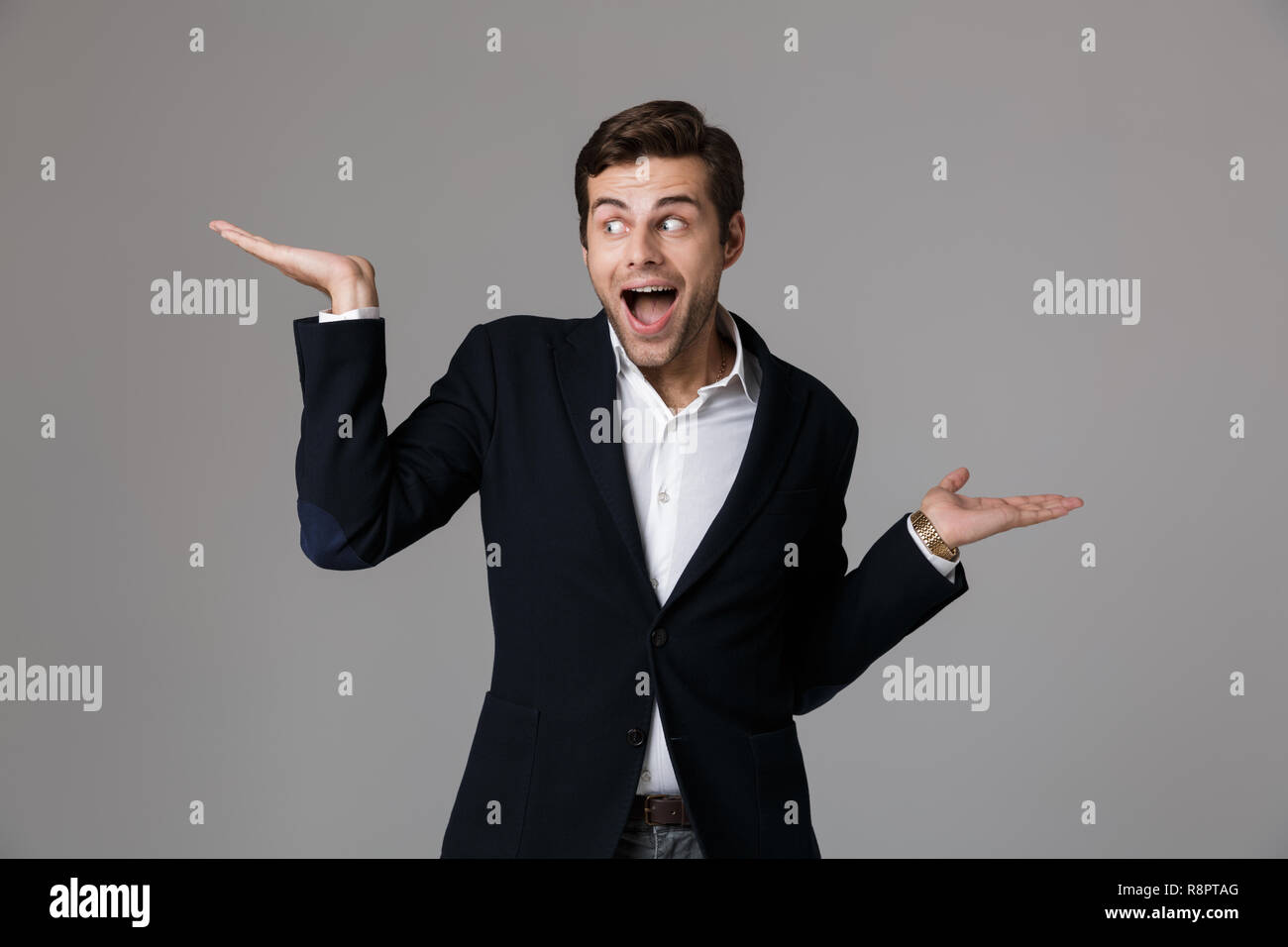 Image of excited businessman 30s in formal suit screaming and throwing ...