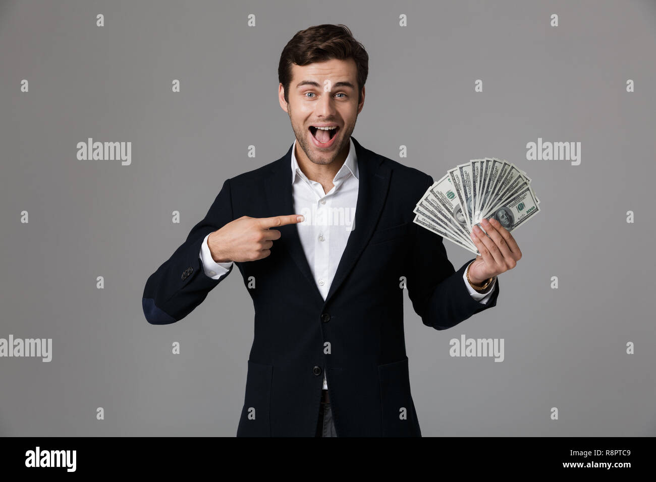 Image of caucasian businessman 30s in suit smiling and holding fan of ...