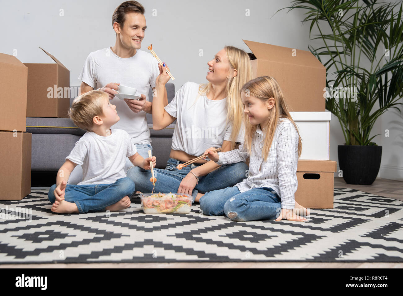 Picture of couple with children eating rice with shrimps sitting on ...