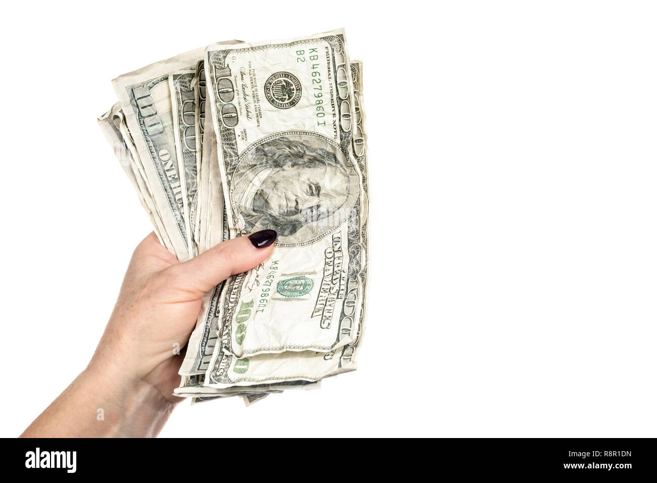 crumpled dollars in female hand with manicure isolated on white ...