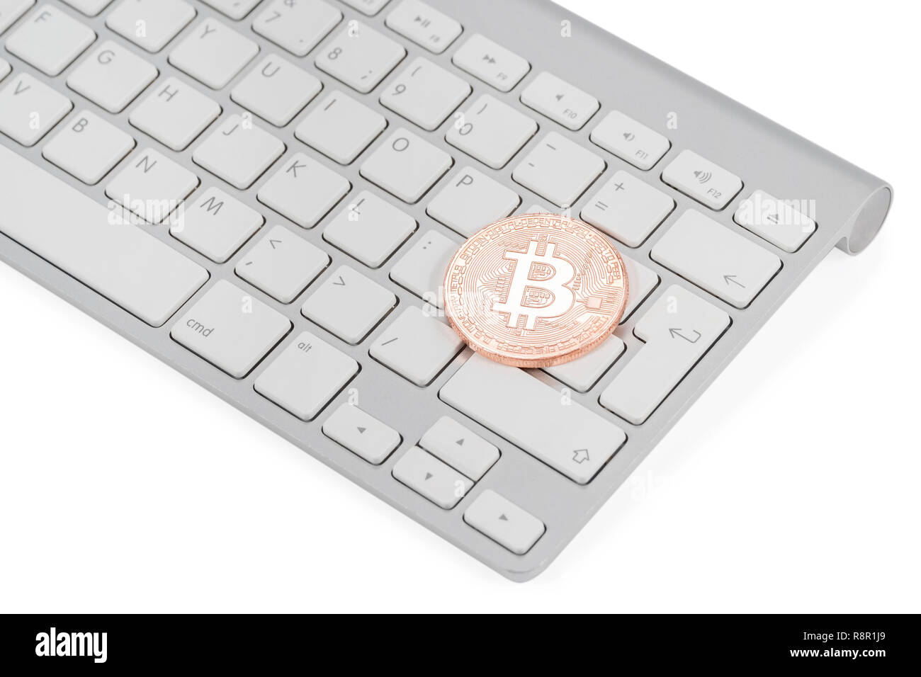 Copper bitcoin coin on white keyboard near enter key isolated on white ...