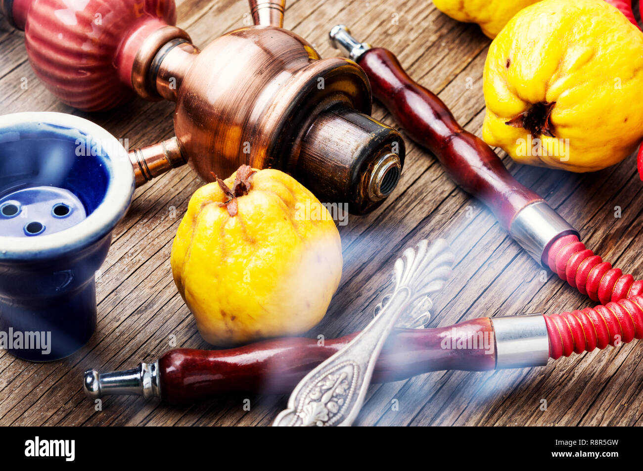 Smoking hookah with mouthpieces with quince flavor.Shisha advertising ...