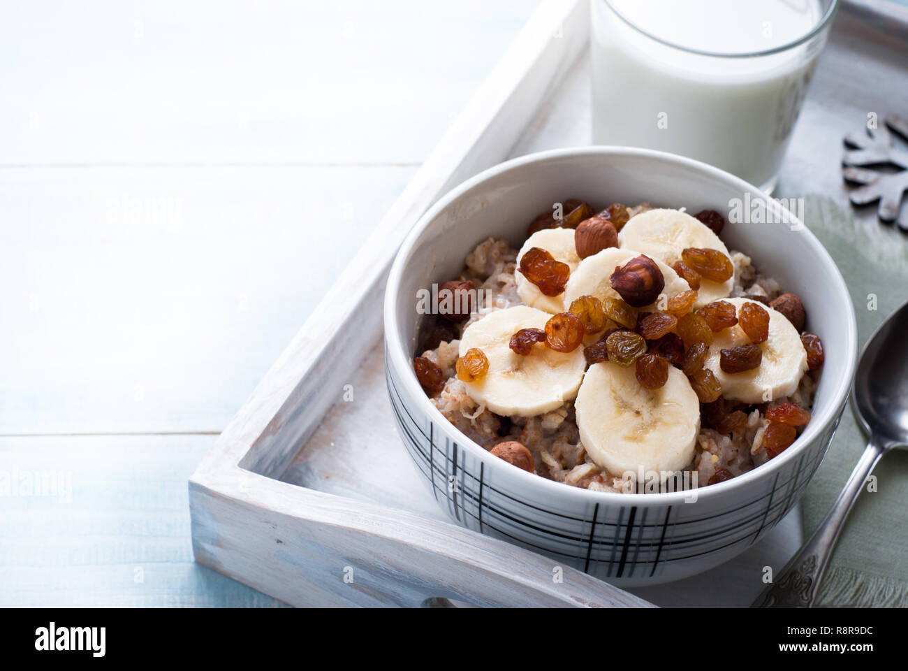 Healthy breakfast - oatmeal with bananas and raisins and a glass of ...