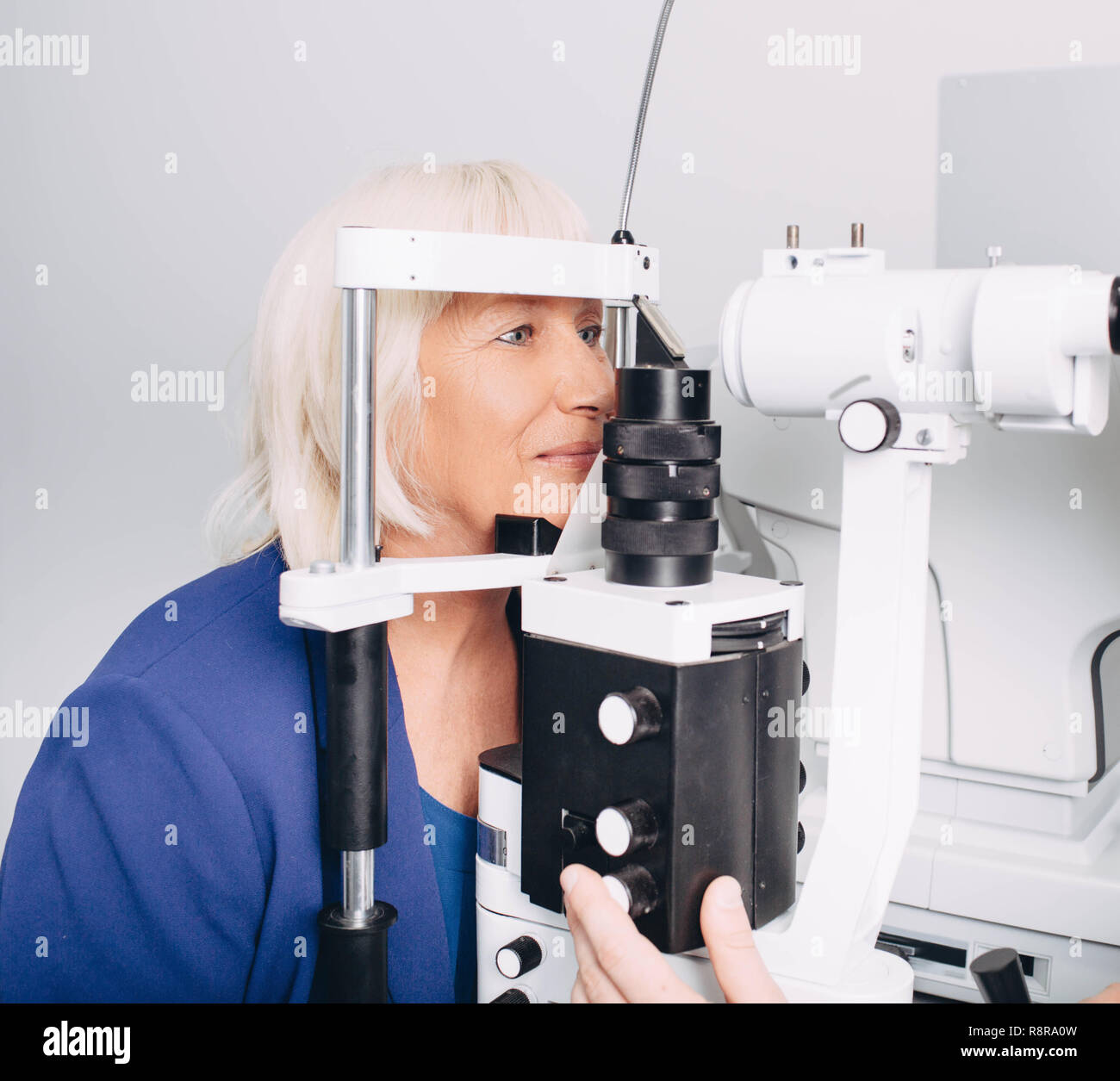 Senior patient receiving eye exam at clinic, eyesight examination aged ...