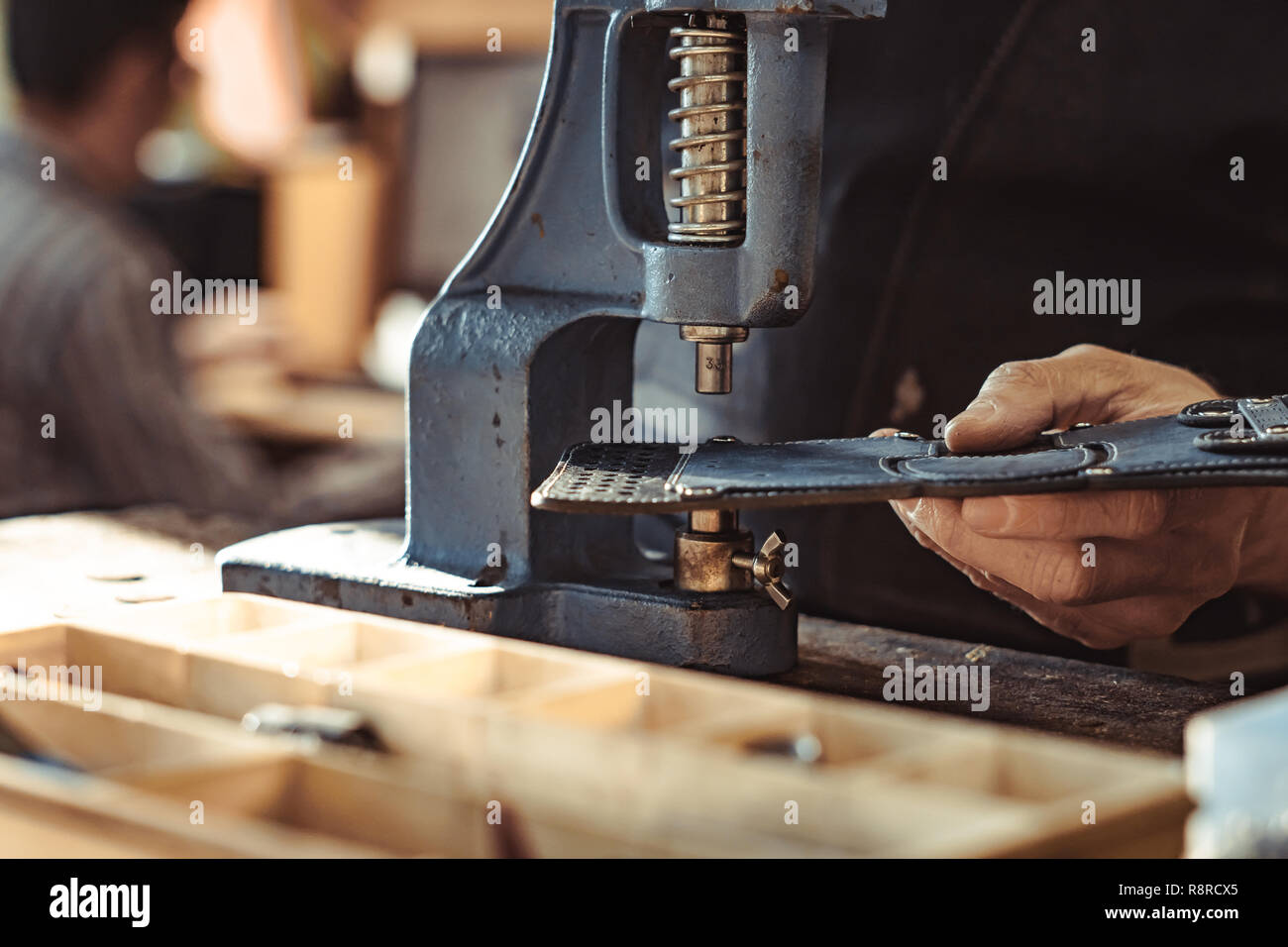 Man works in carpentry workshop. He fixes wooden handle in vice ...