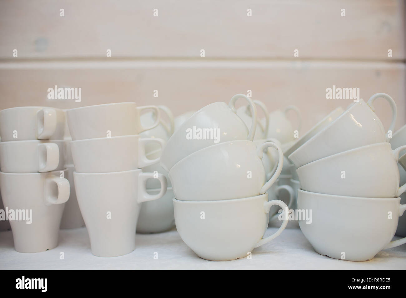 many rows pure white cup and saucer with teaspoon, reflection on table ...