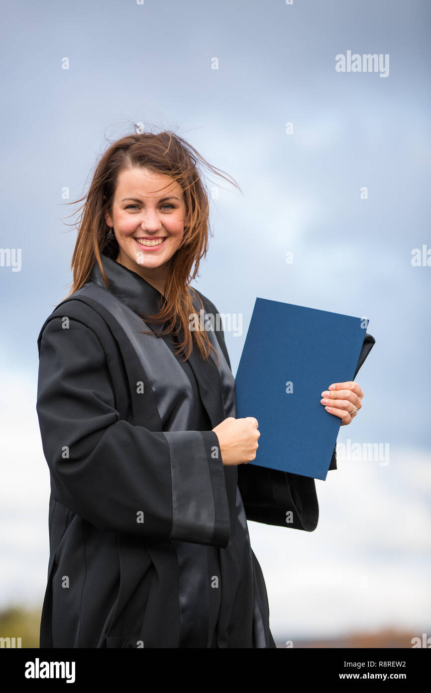 Pretty, young woman celebrating joyfully her graduation - spreading ...
