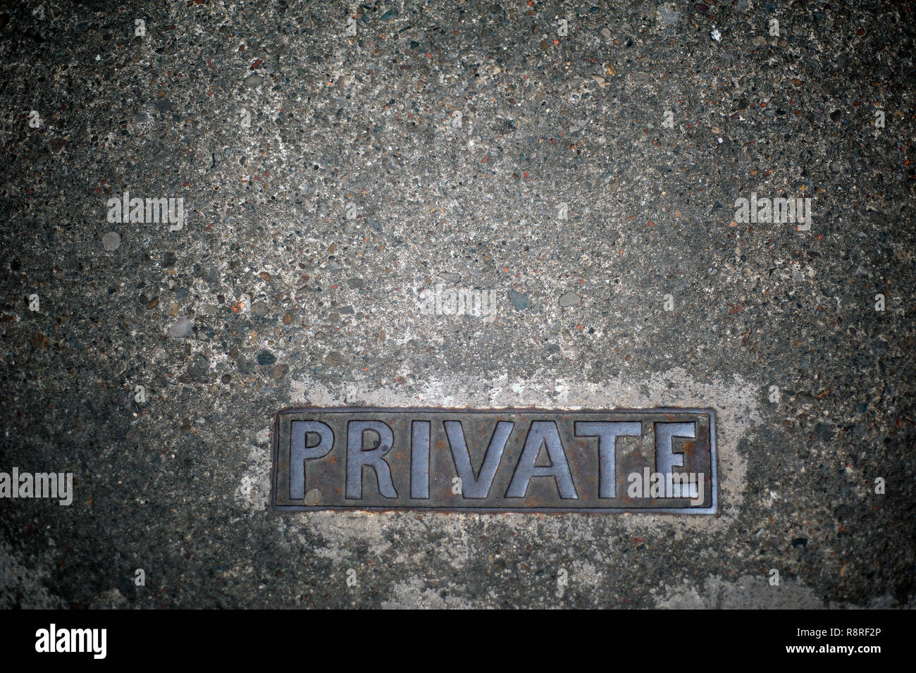 Cast metal 'PRIVATE' words embedded in tarmac Stock Photo - Alamy