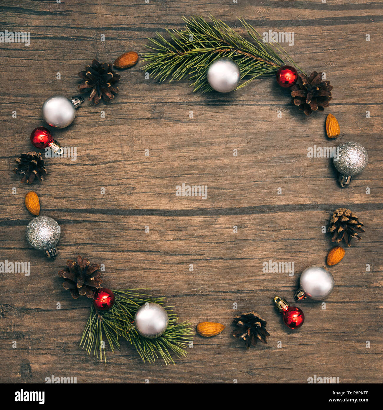 Round composition of fir branches, pine cones, almonds, red and silver ...