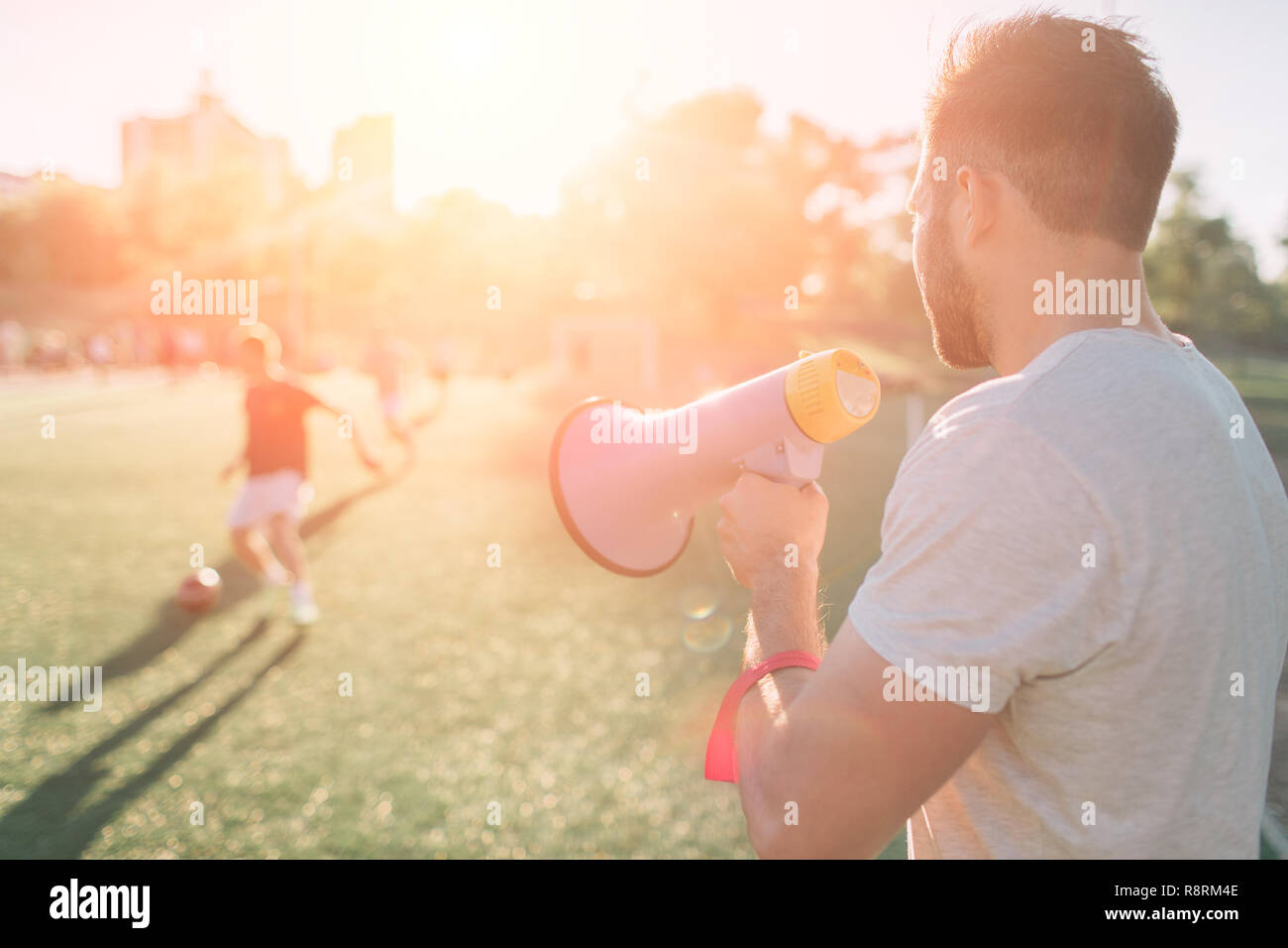 The head coach screams into the megaphone. Football game. Concept Stock ...