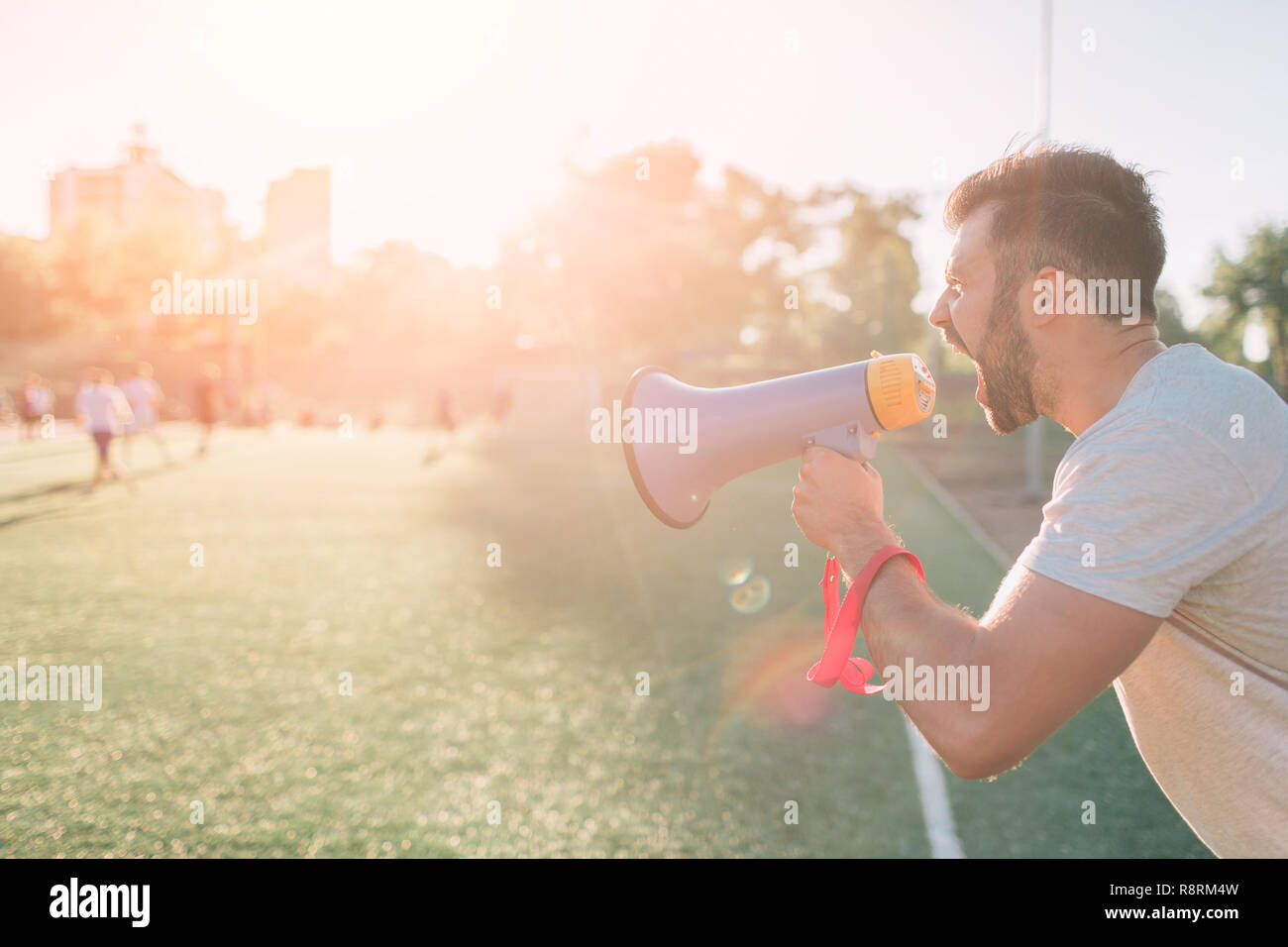 The head coach screams into the megaphone. Football game. Concept Stock ...