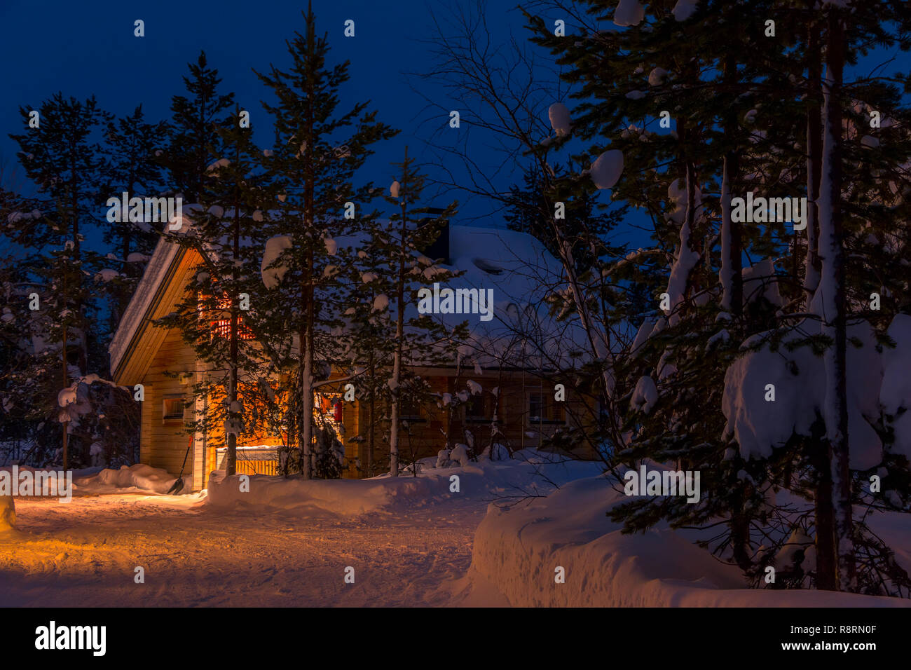 Finnish Lapland. Cottage in the night winter forest. A lot of snow ...
