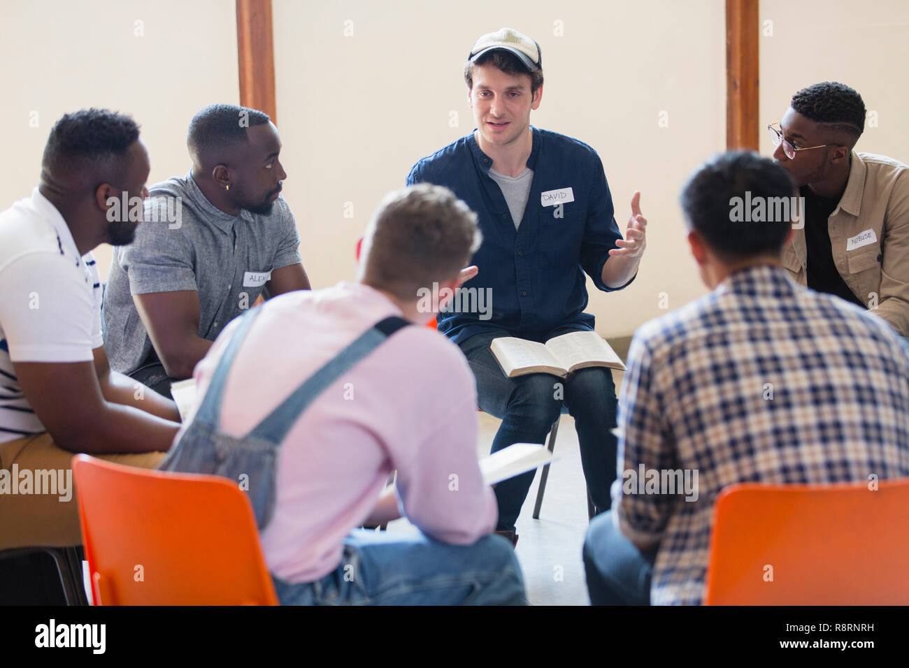 Men reading and discussing bible in prayer group Stock Photo - Alamy