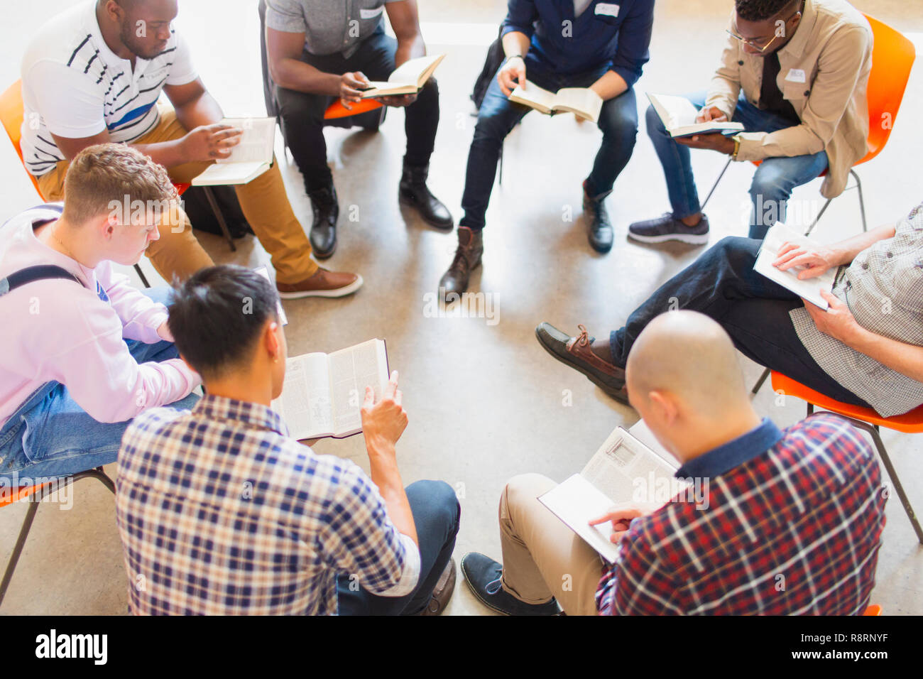 Men reading and discussing bible in prayer group Stock Photo - Alamy