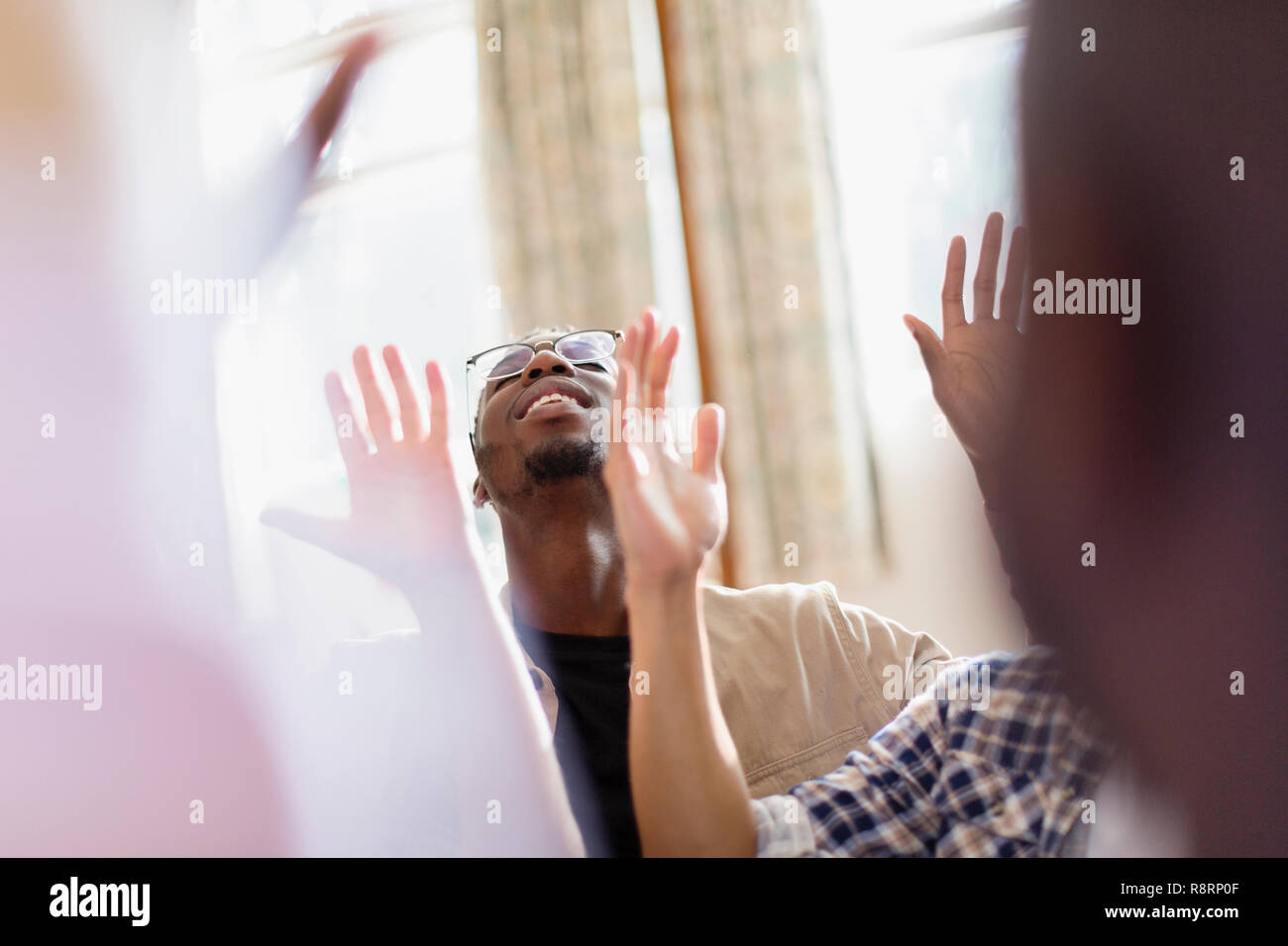 Smiling man with arms raised praying in prayer group Stock Photo - Alamy