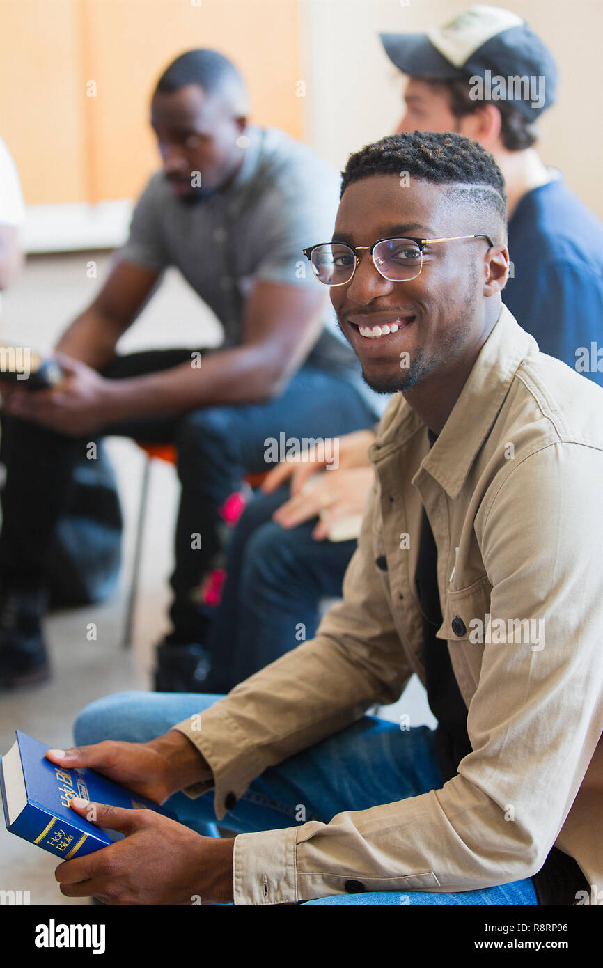Portrait smiling man holding bible in prayer group Stock Photo - Alamy