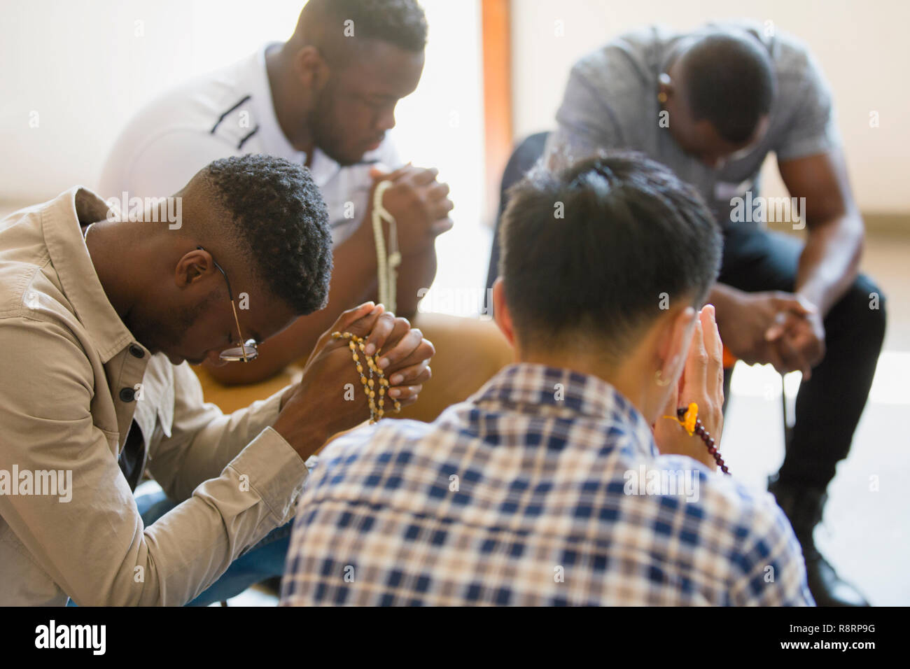 Men praying with rosaries in prayer group Stock Photo - Alamy
