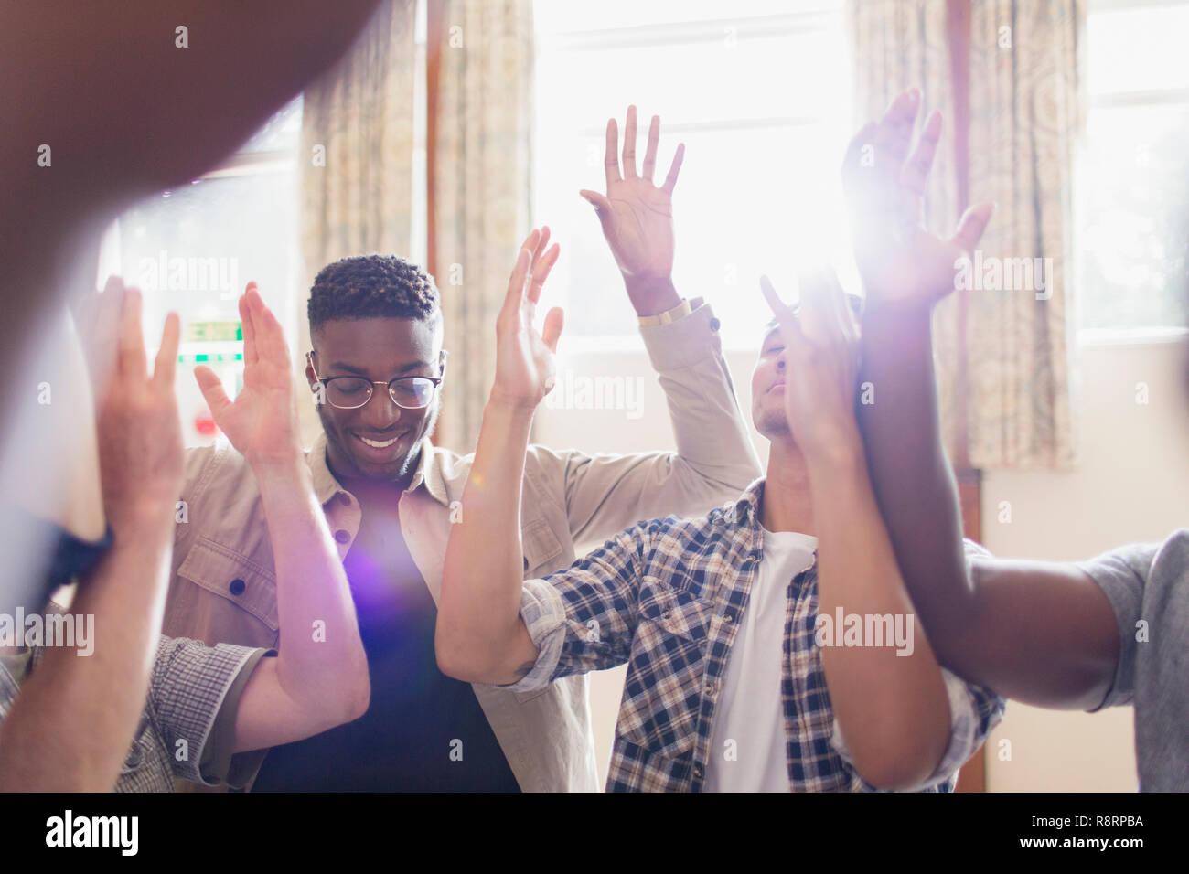 Men praying with arms raised in prayer group Stock Photo - Alamy