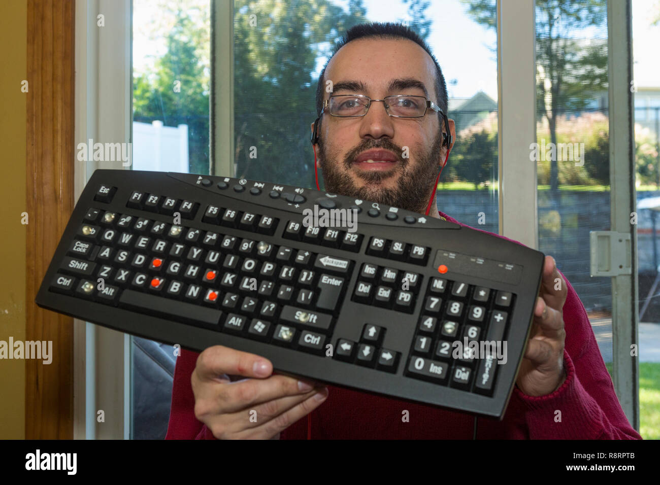 Man with Visual Impairment holding up his keyboard that lets him hear ...