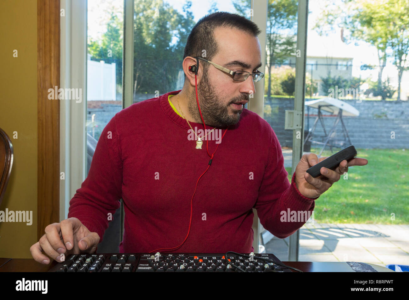 Man with Visual Impairment listening to his phone Stock Photo - Alamy