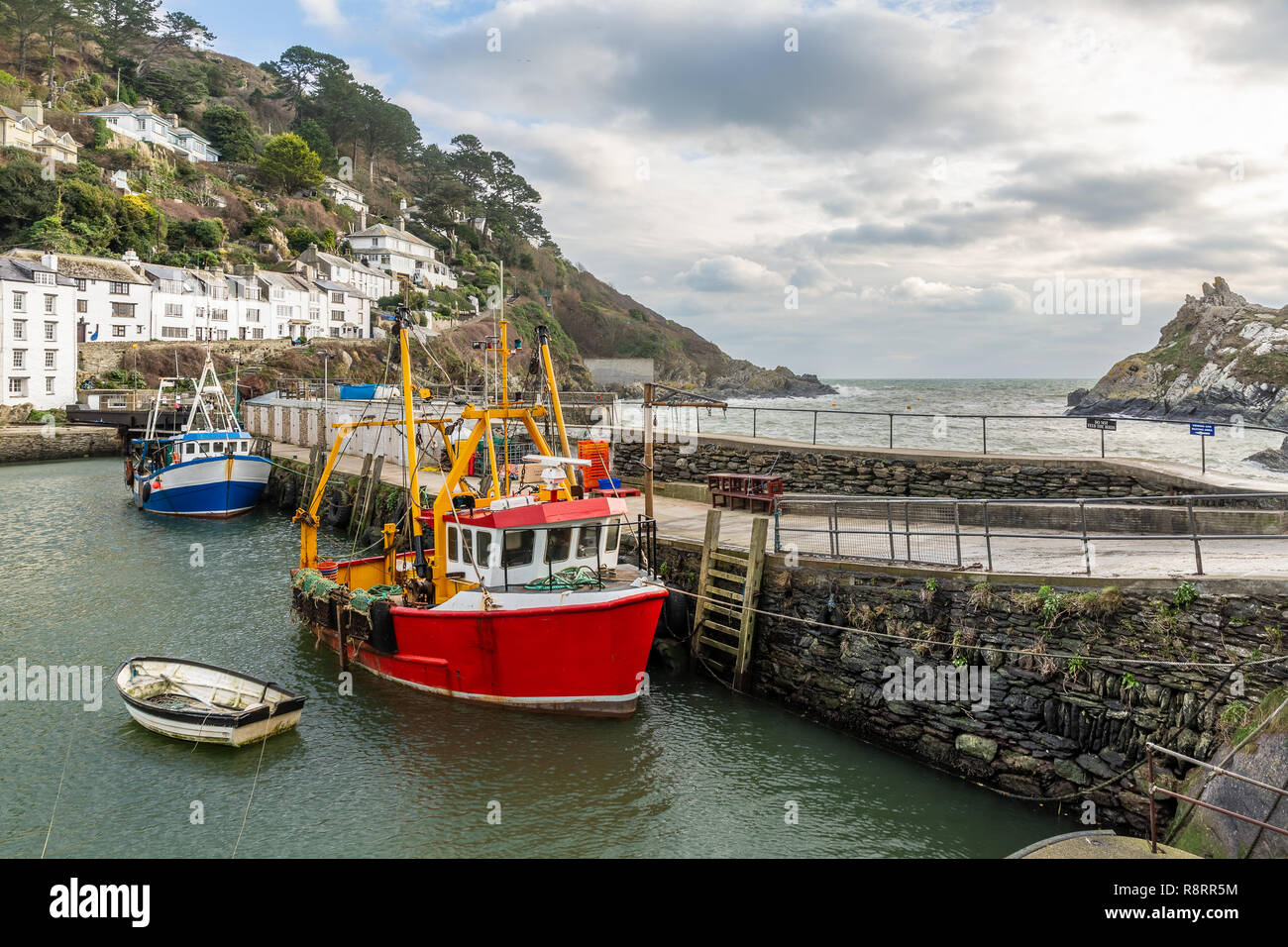 Red and Blue fishing boats moored at Polperro Harbour, Cornwall, with ...