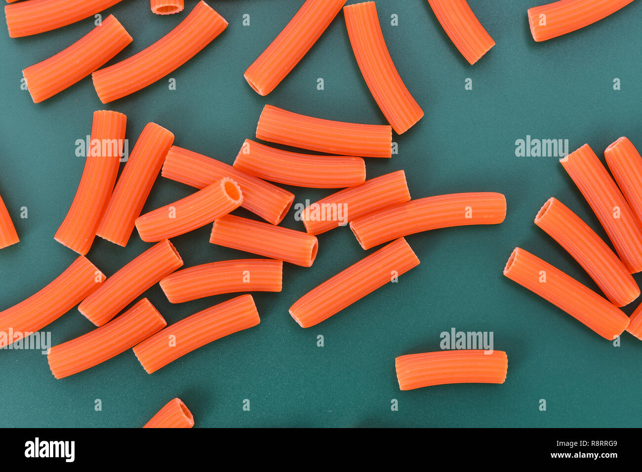 red macaroni (tomato) with green background Stock Photo - Alamy