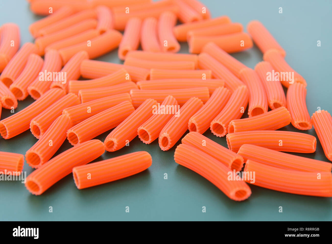 red macaroni (tomato) with green background Stock Photo - Alamy