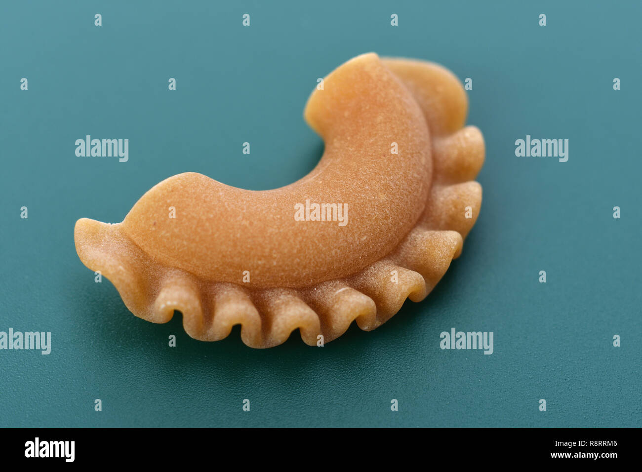 Pasta creste di gallo on green background Stock Photo - Alamy