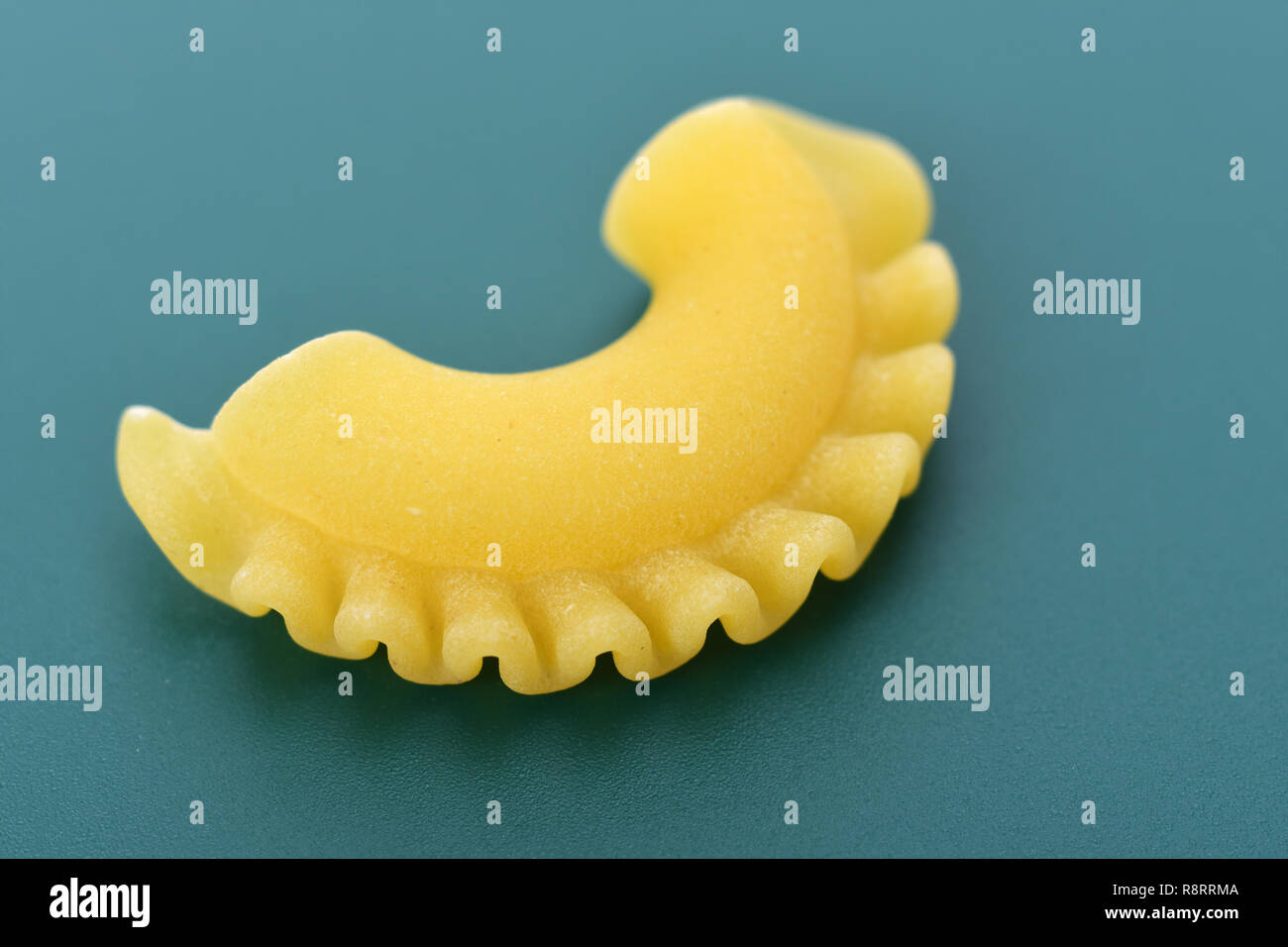 Pasta creste di gallo on green background Stock Photo - Alamy