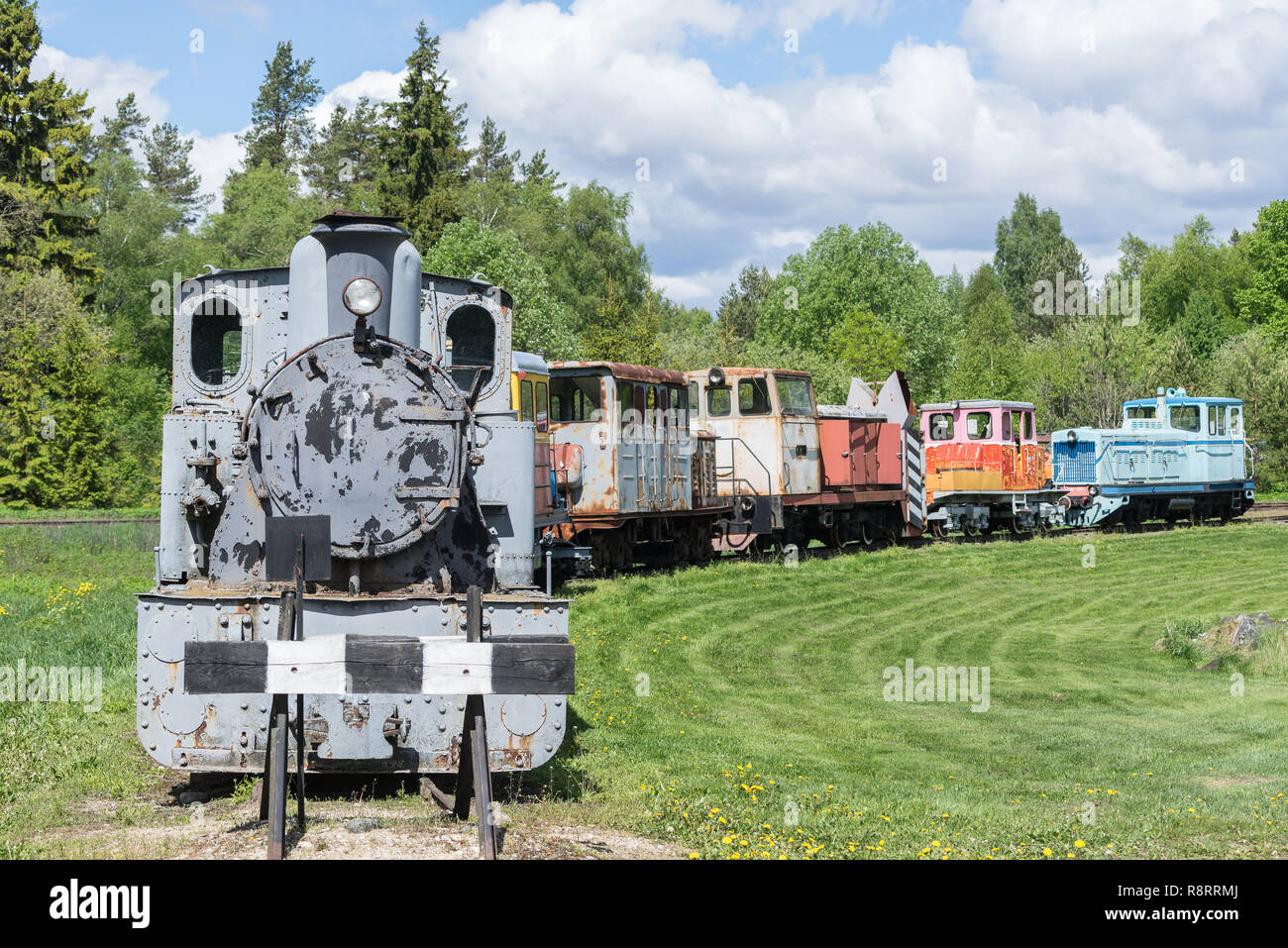 Old train and locomotive. Railroad tracks stretches and green grass and ...
